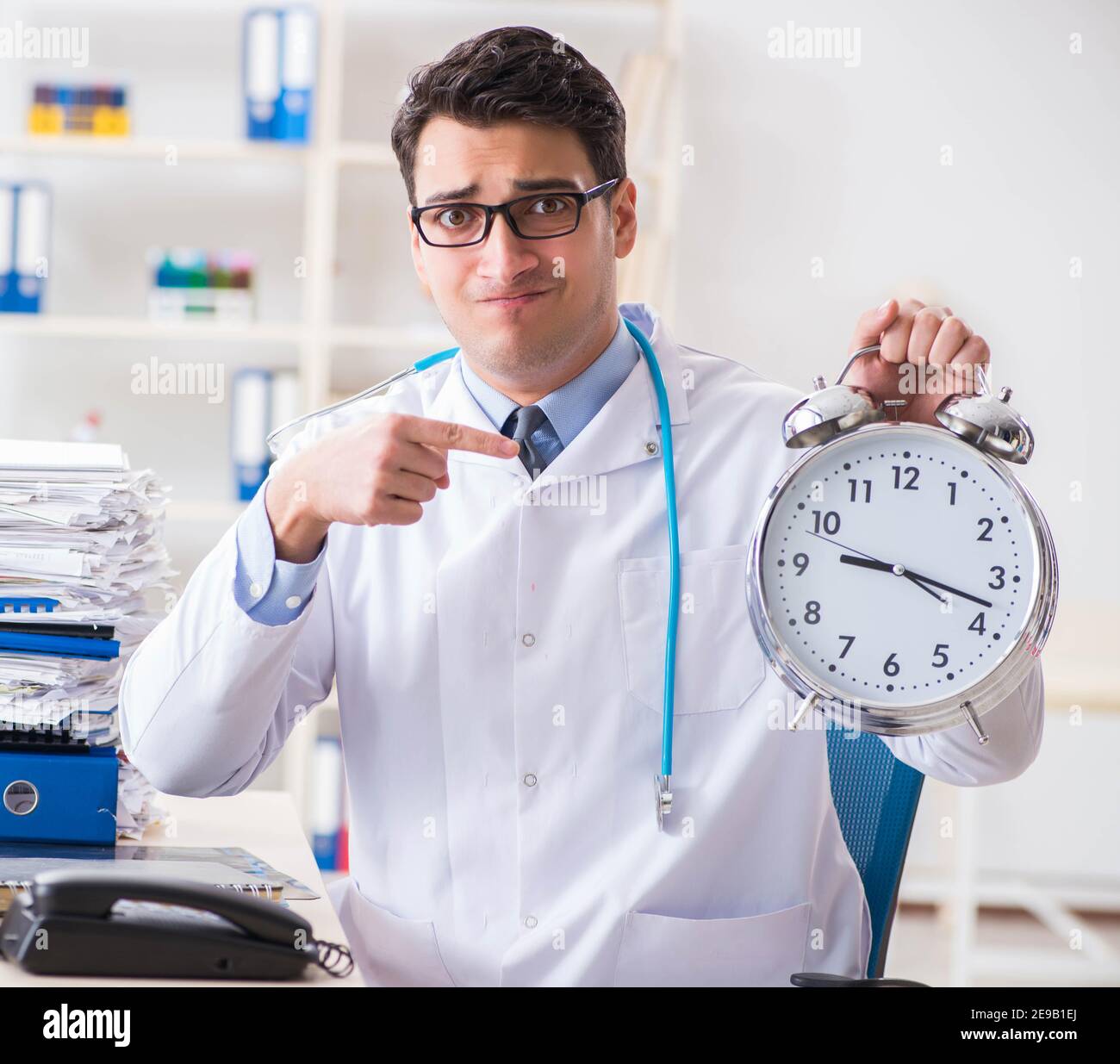 The doctor with alarm clock in urgent check-up concept Stock Photo - Alamy