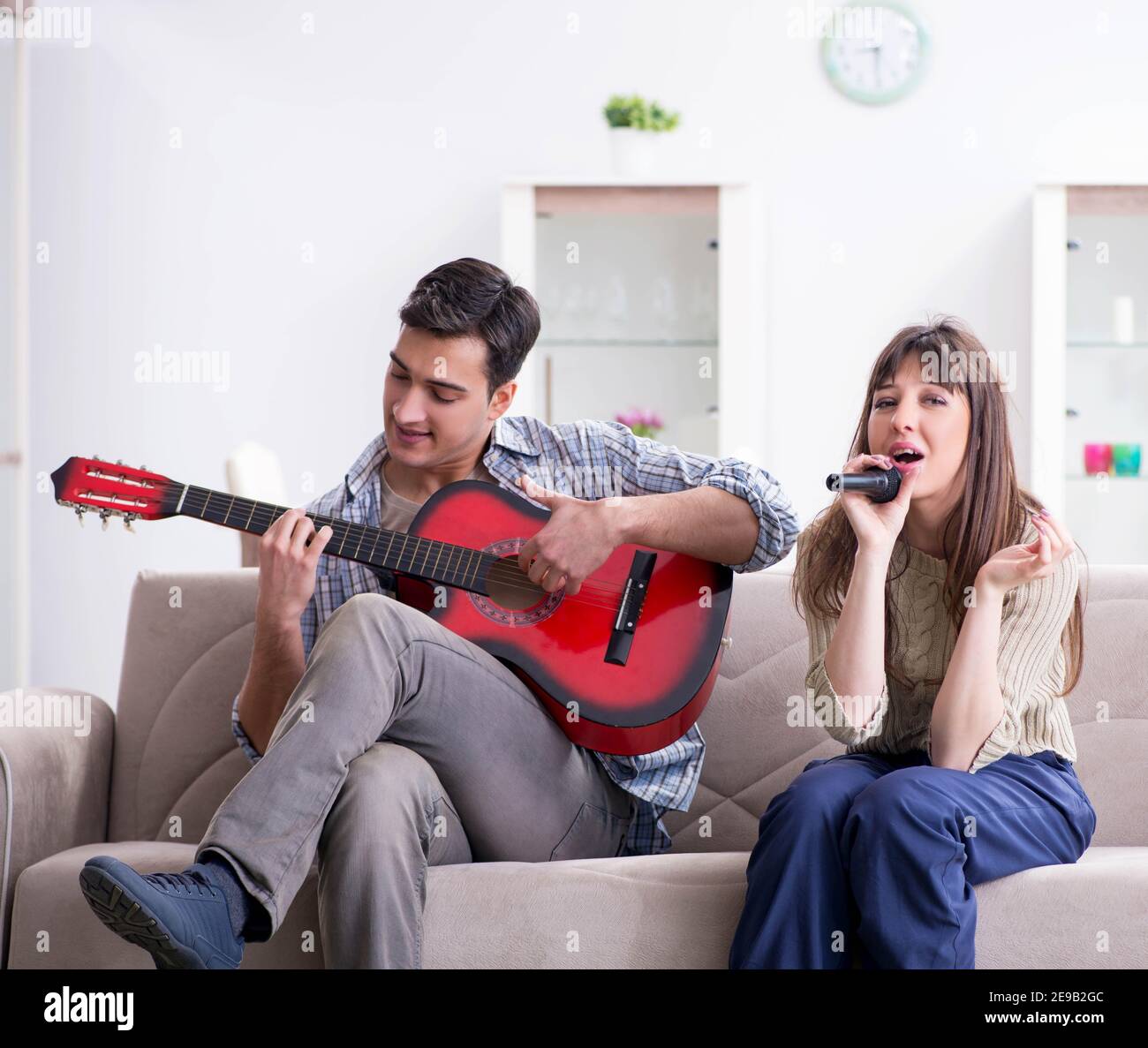 The young family singing and playing music at home Stock Photo - Alamy