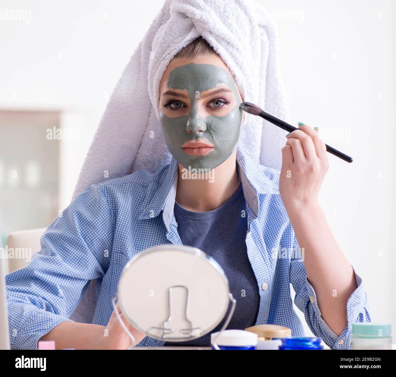 The woman applying clay mask with brush at home Stock Photo - Alamy