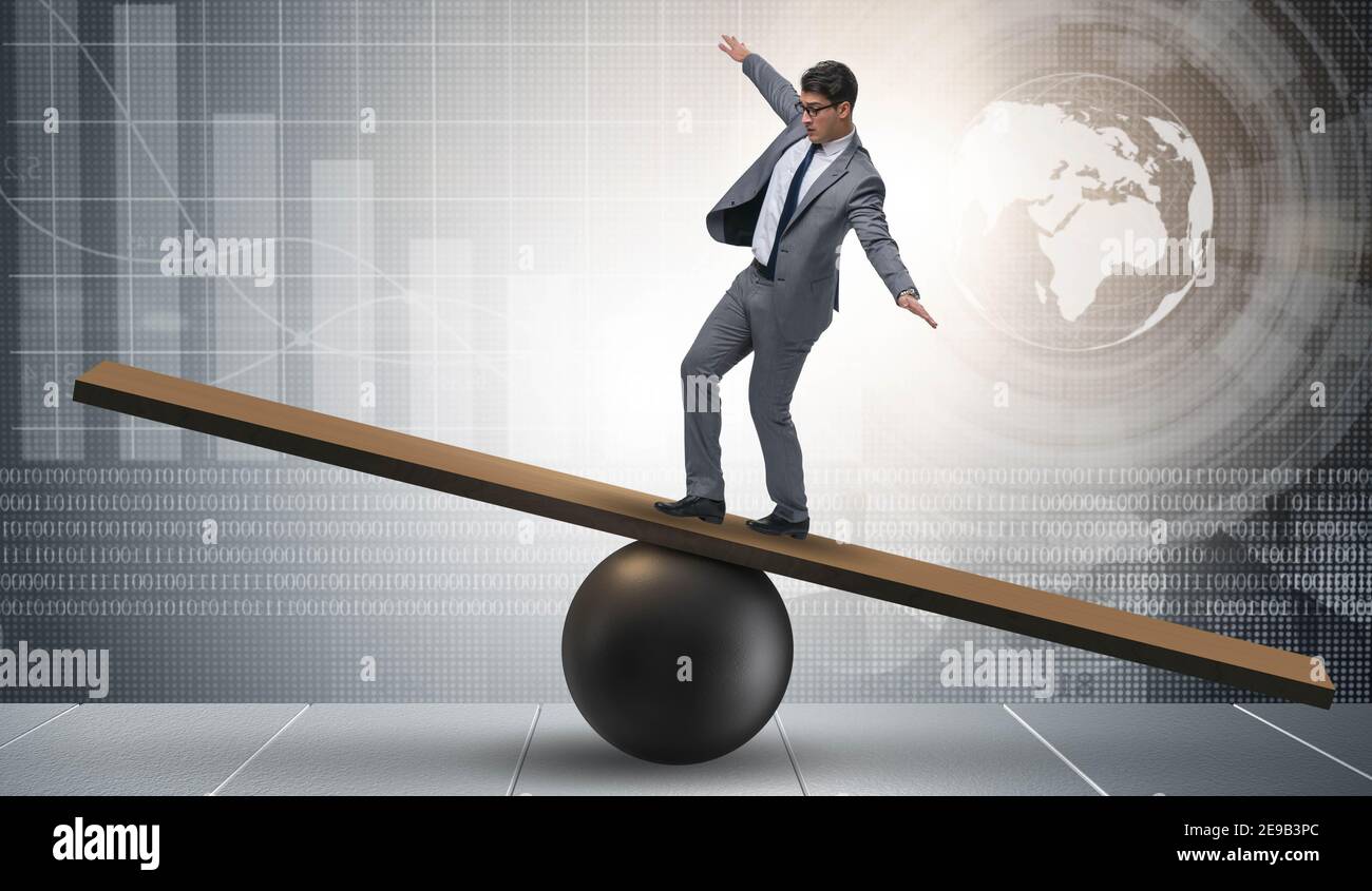 The businessman trying to balance on ball and seesaw Stock Photo - Alamy