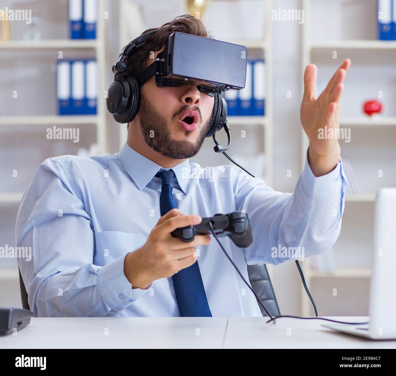 The businessman gamer in office playing games Stock Photo - Alamy