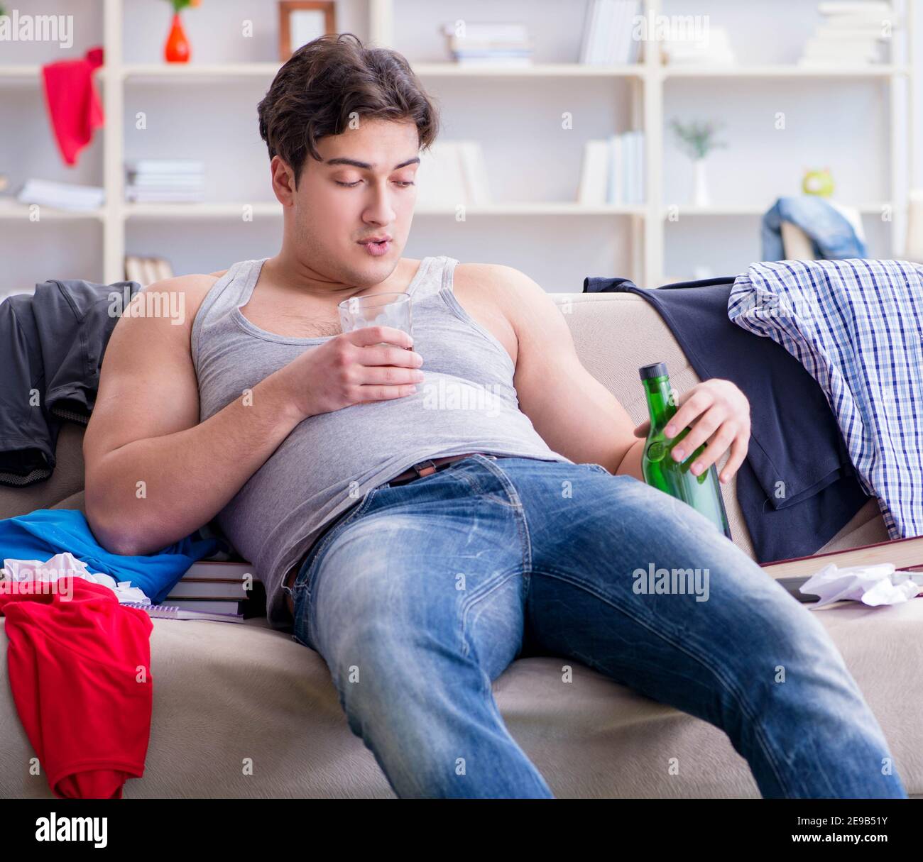 The young man student drunk drinking alcohol in a messy room Stock ...