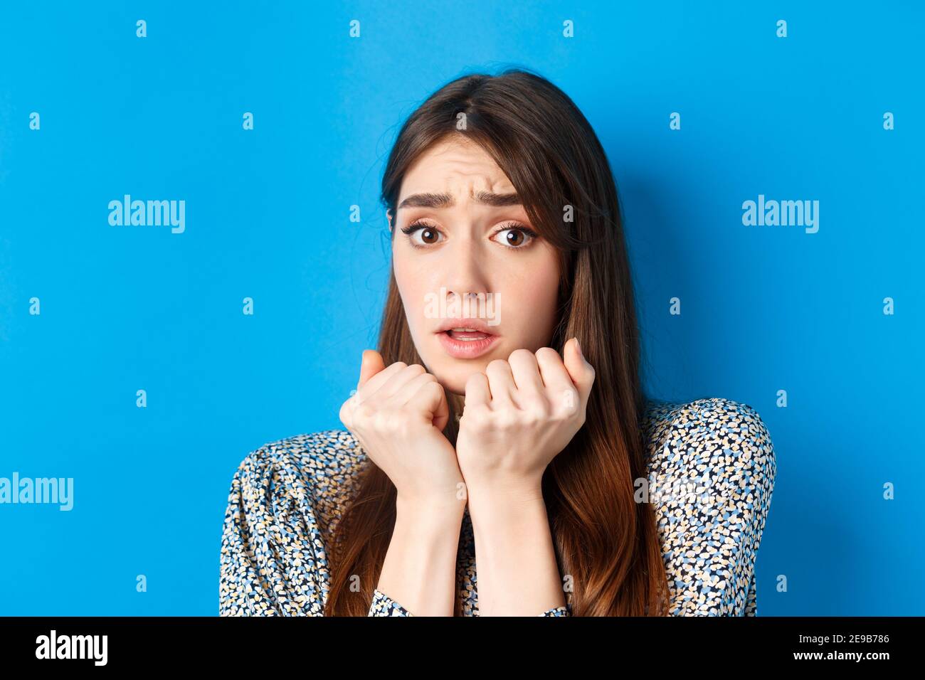 Close-up of scared timid girl looking afraid, shaking from fear, press ...