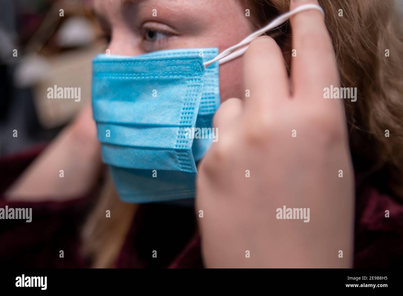 White woman wearing double face masks for covid prevention, side shot ...