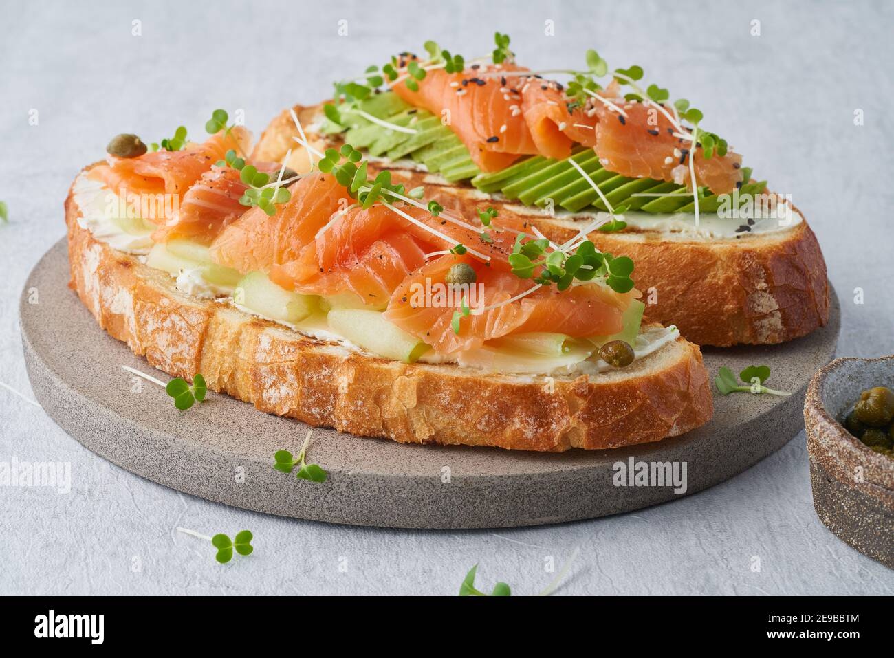 Two open sandwich, toast with salmon, cream cheese, avocado, cucumber ...
