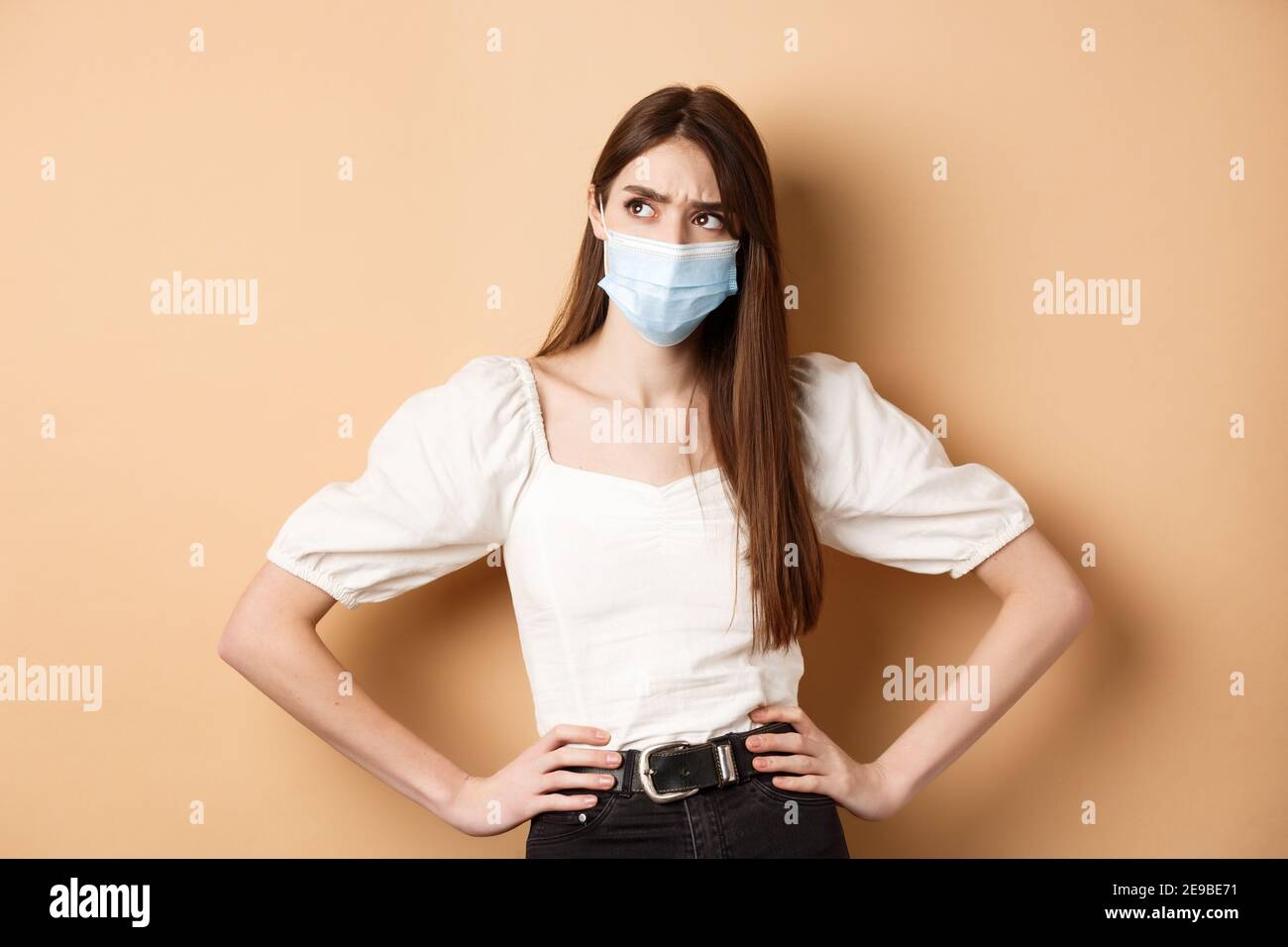 Covid-19 and lifestyle concept. Suspicious woman in medical mask ...