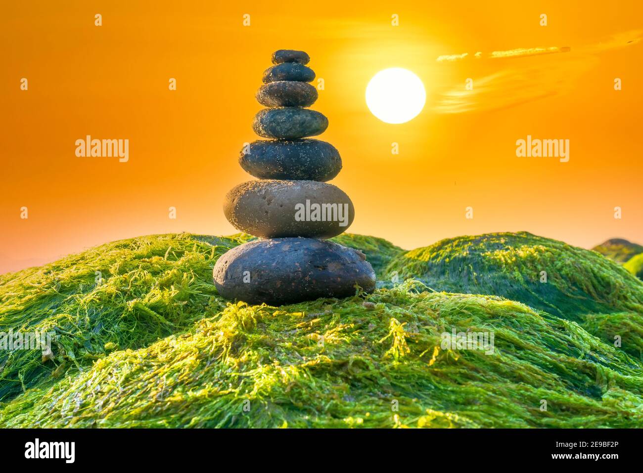 Stacked Pebbles art on mossy rocks welcomes beautiful new day Stock ...