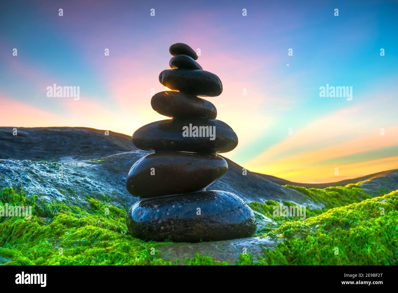 Stacked Pebbles art on mossy rocks welcomes beautiful new day Stock ...