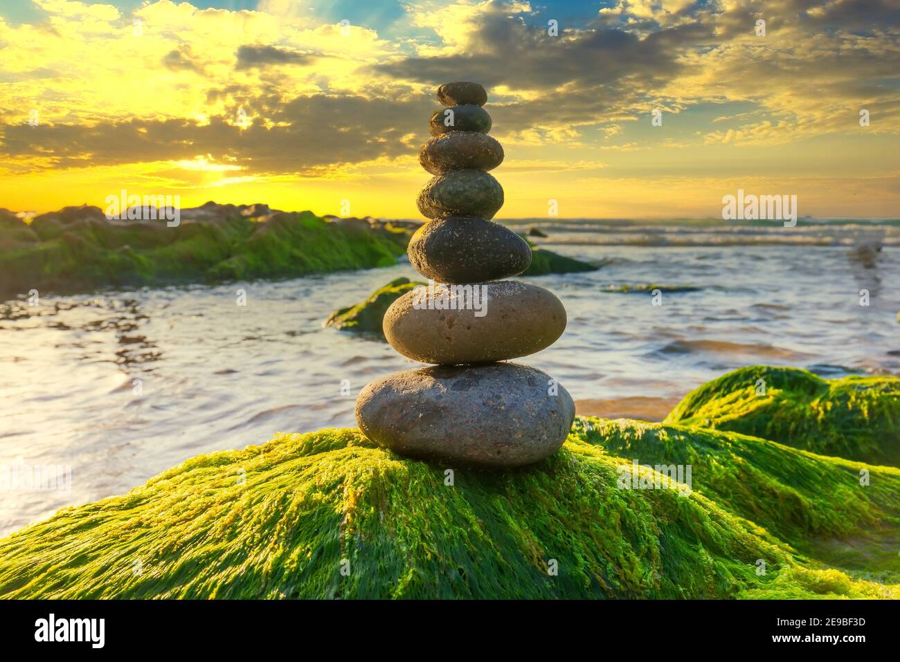 Stacked Pebbles art on mossy rocks welcomes beautiful new day Stock ...