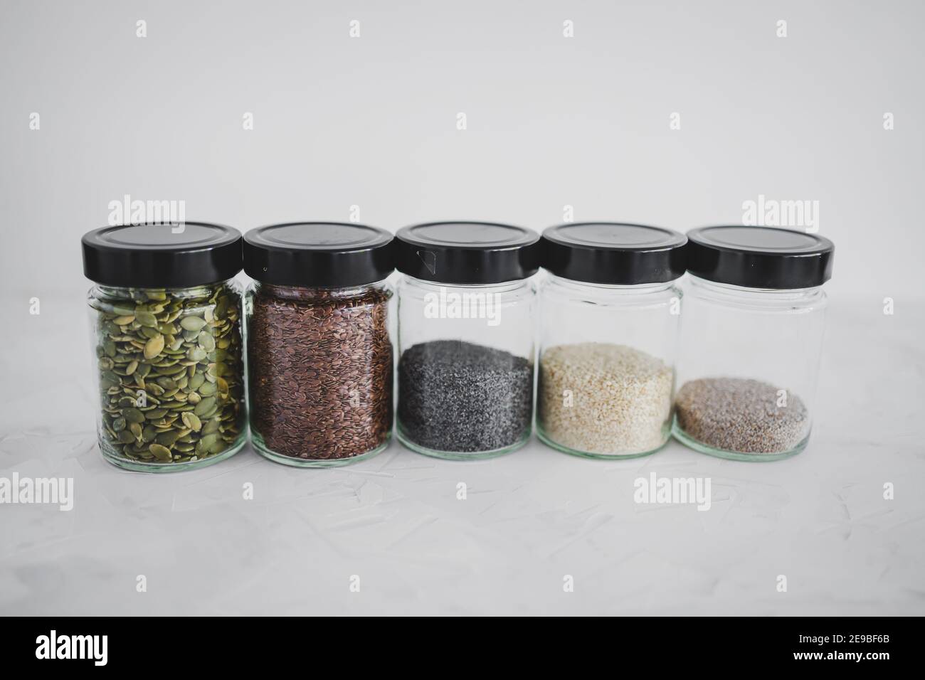 simple food ingredients concept, seed jars with sesame poppy pupmkin ...