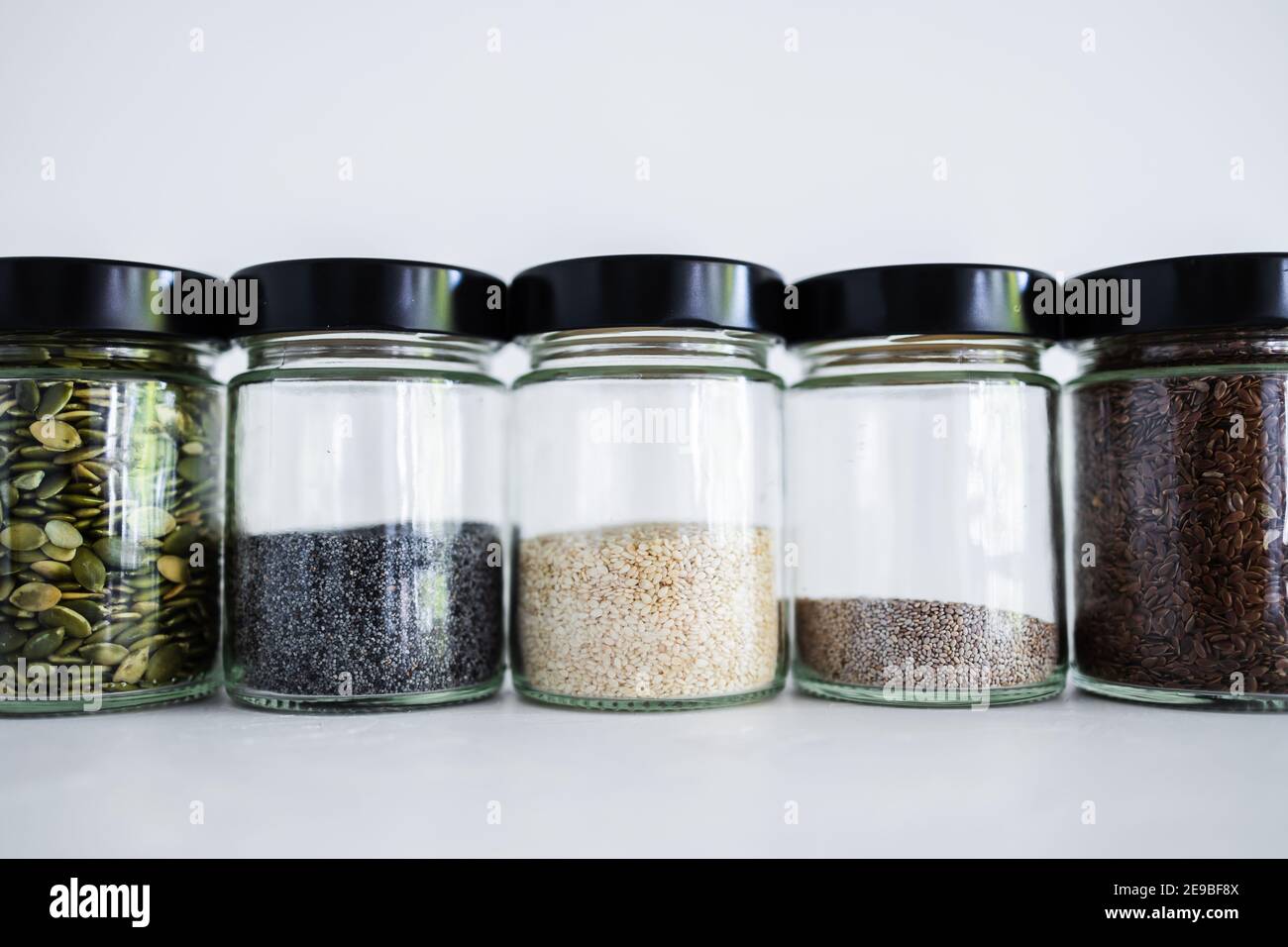 simple food ingredients concept, seed jars with sesame poppy pupmkin ...