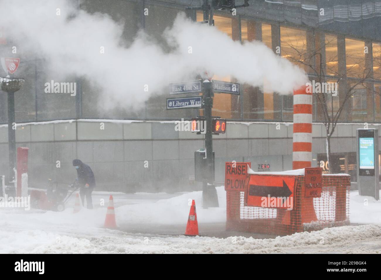 A worker with a snow thrower and a New York Steam Pipe Stock Photo - Alamy