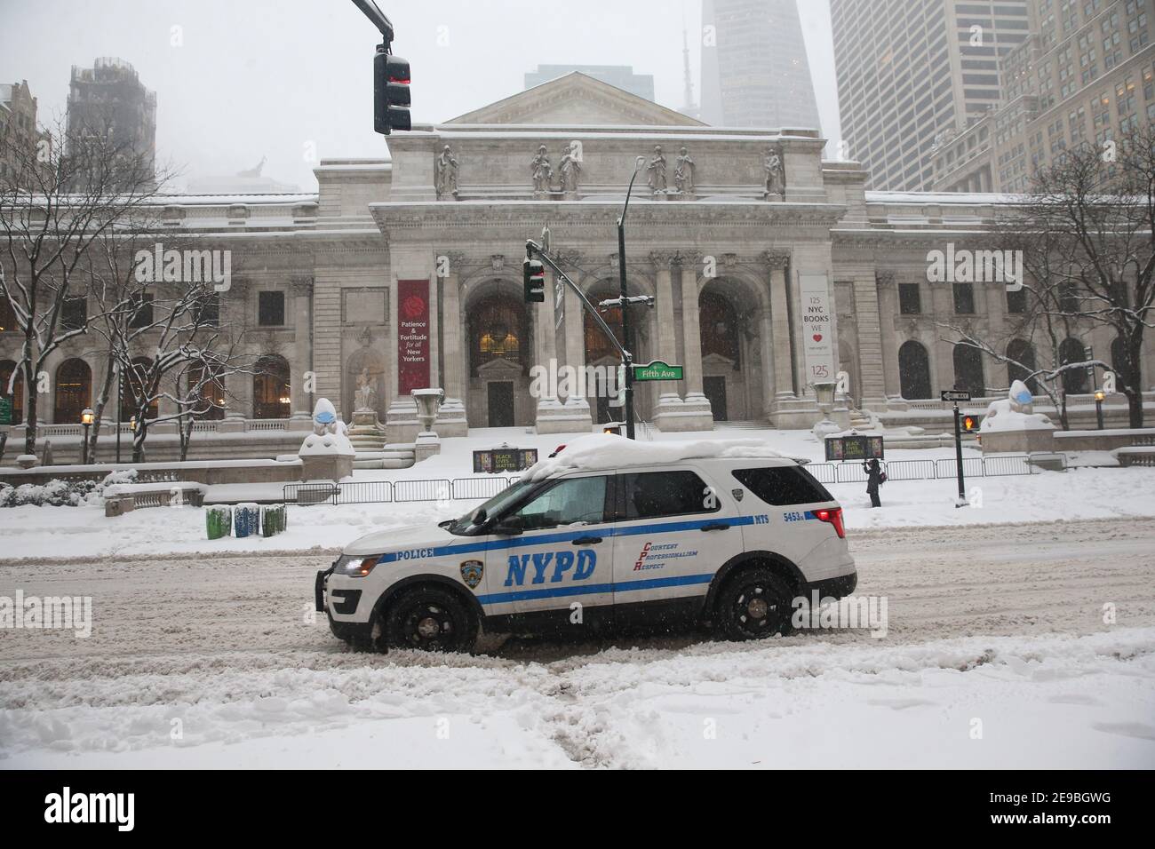 A snow covered Police Car passes Main New York Public Library building ...