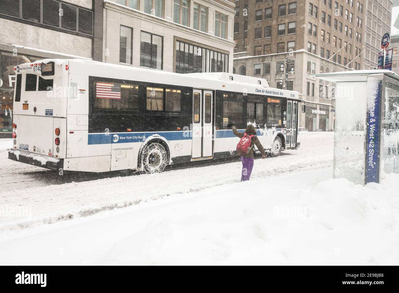 New York City USA Person flagging down bus on Fifth Avenue in a snow ...