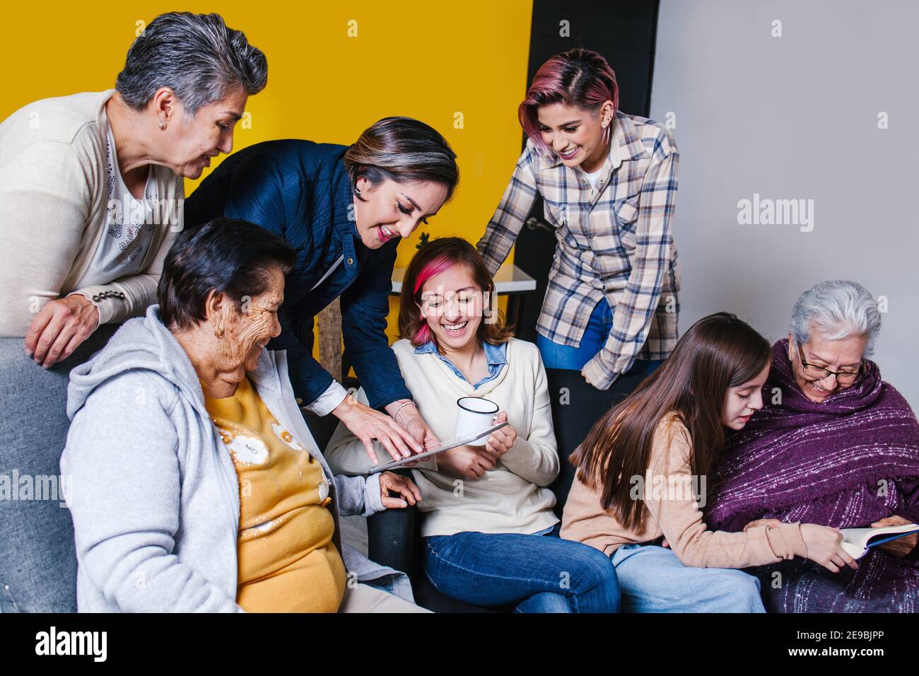 Latin family three generation of Mexican women sitting on sofa in ...