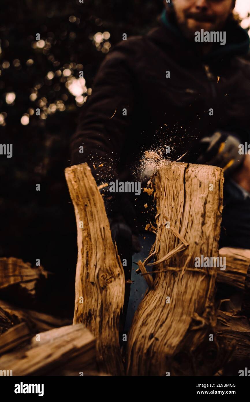 Chopping logs for firewood in action and close up with particles flying ...