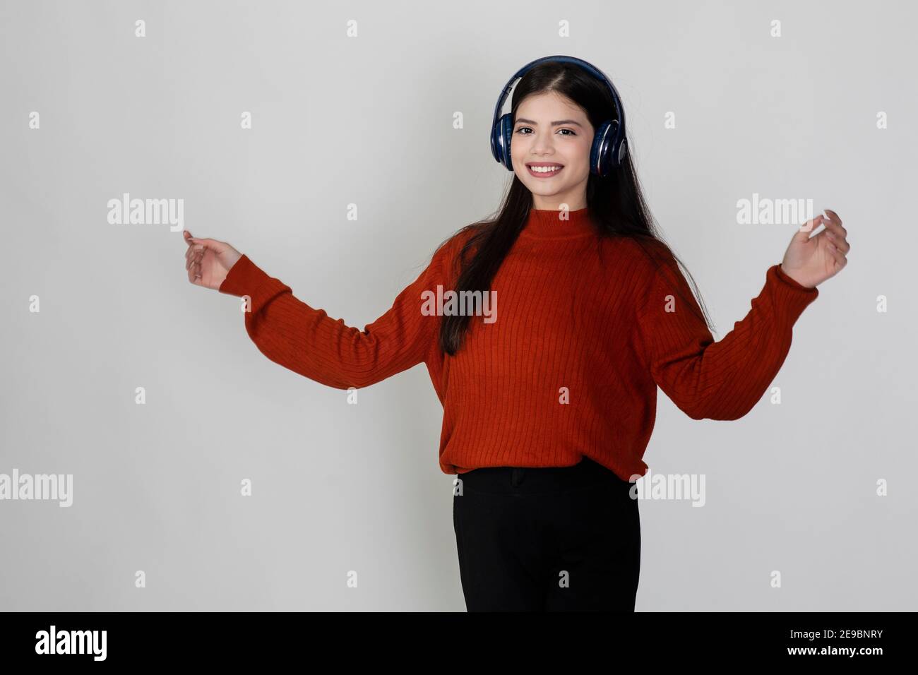Pretty excited young girl wearing headphone and listening to music or ...