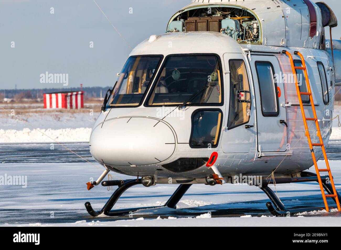 Close-up of a white helicopter with an open engine on the apron of a ...