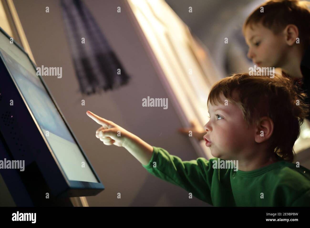 Boy looking at monitor in a library Stock Photo - Alamy