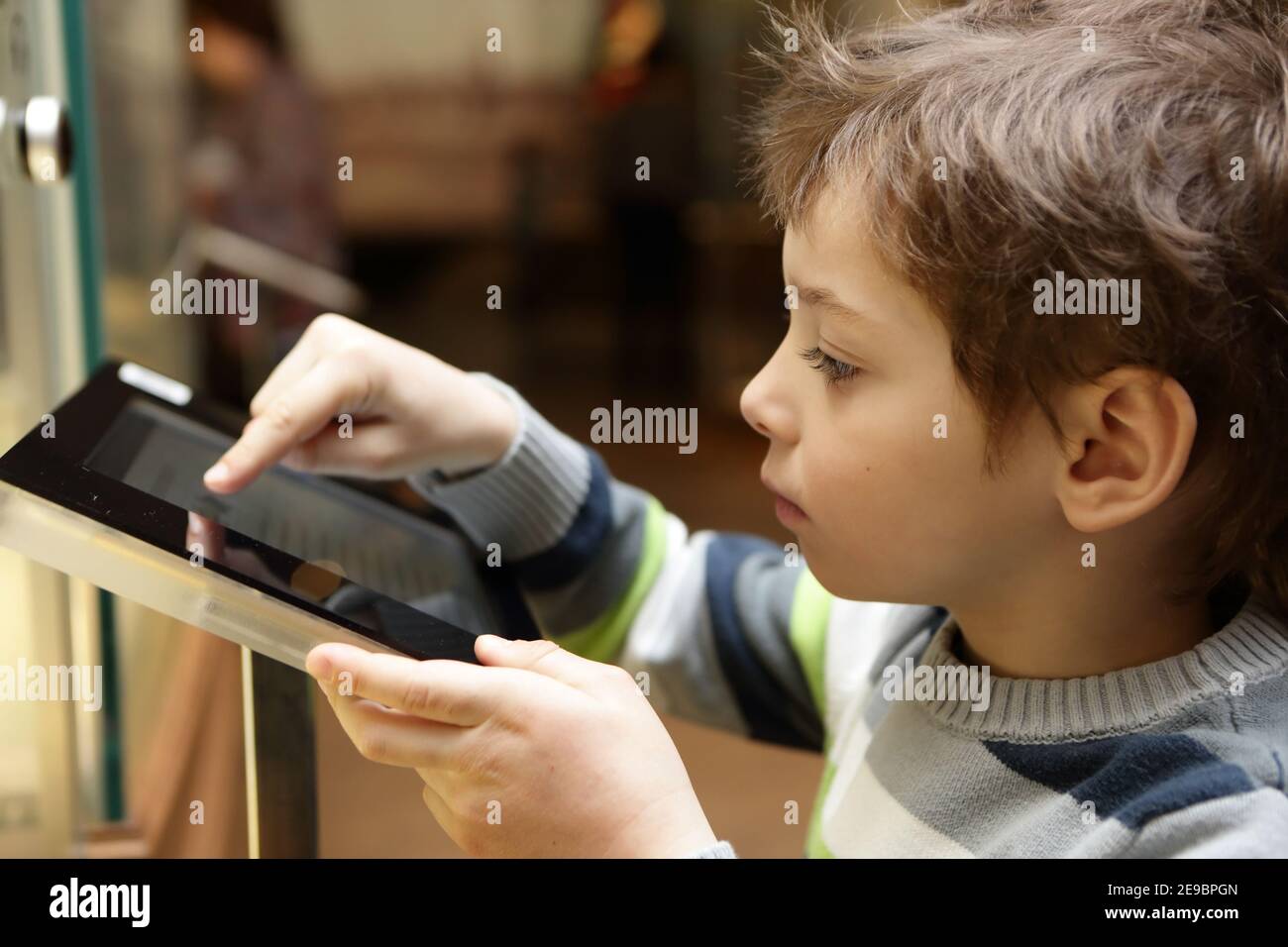 Boy using touch screen in a museum Stock Photo - Alamy