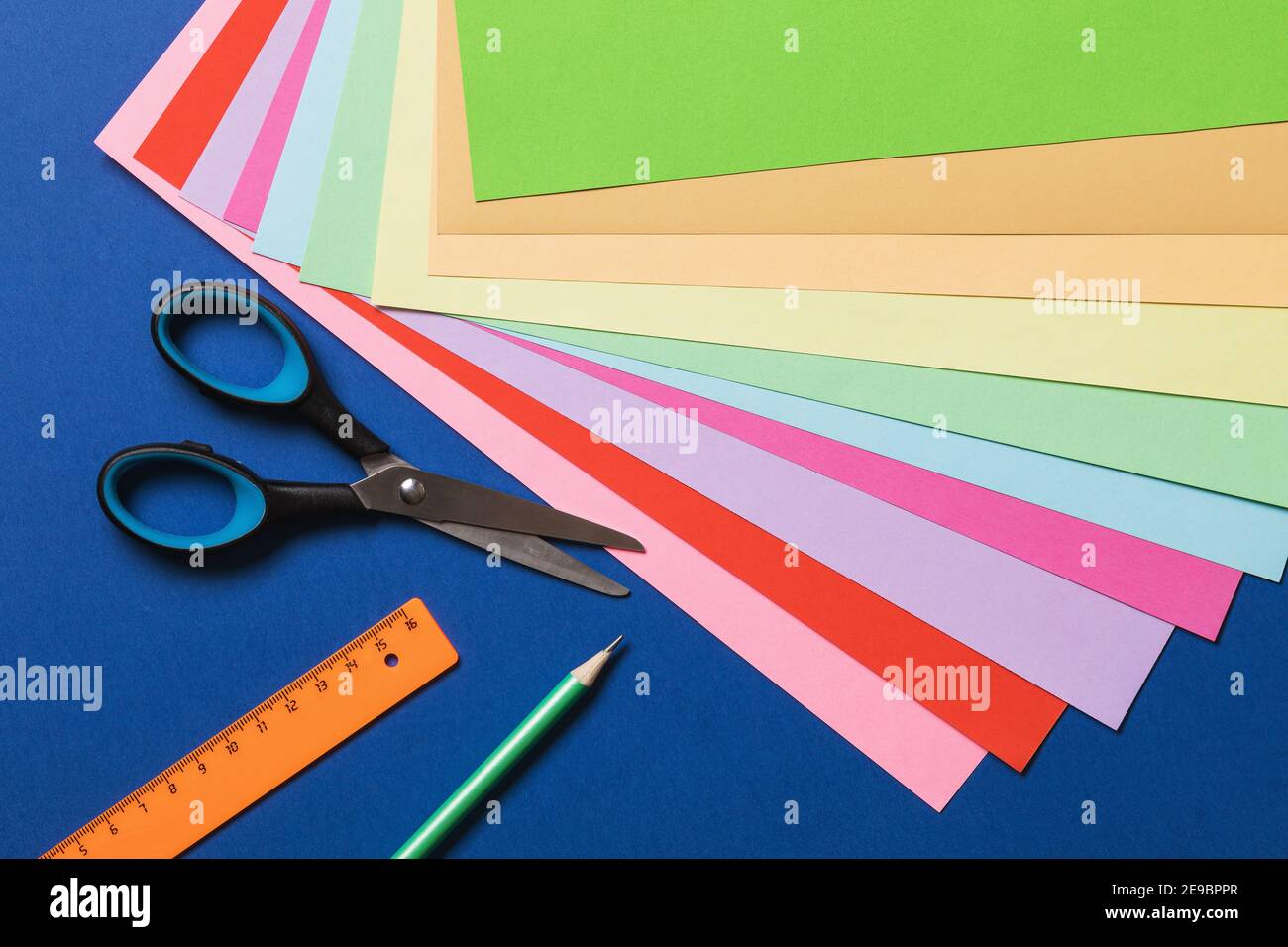 Colored paper and tools on a blue background, top view Stock Photo - Alamy