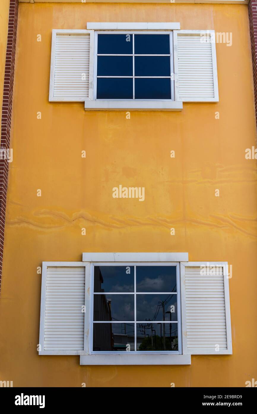White windows and yellow color wall background Stock Photo - Alamy