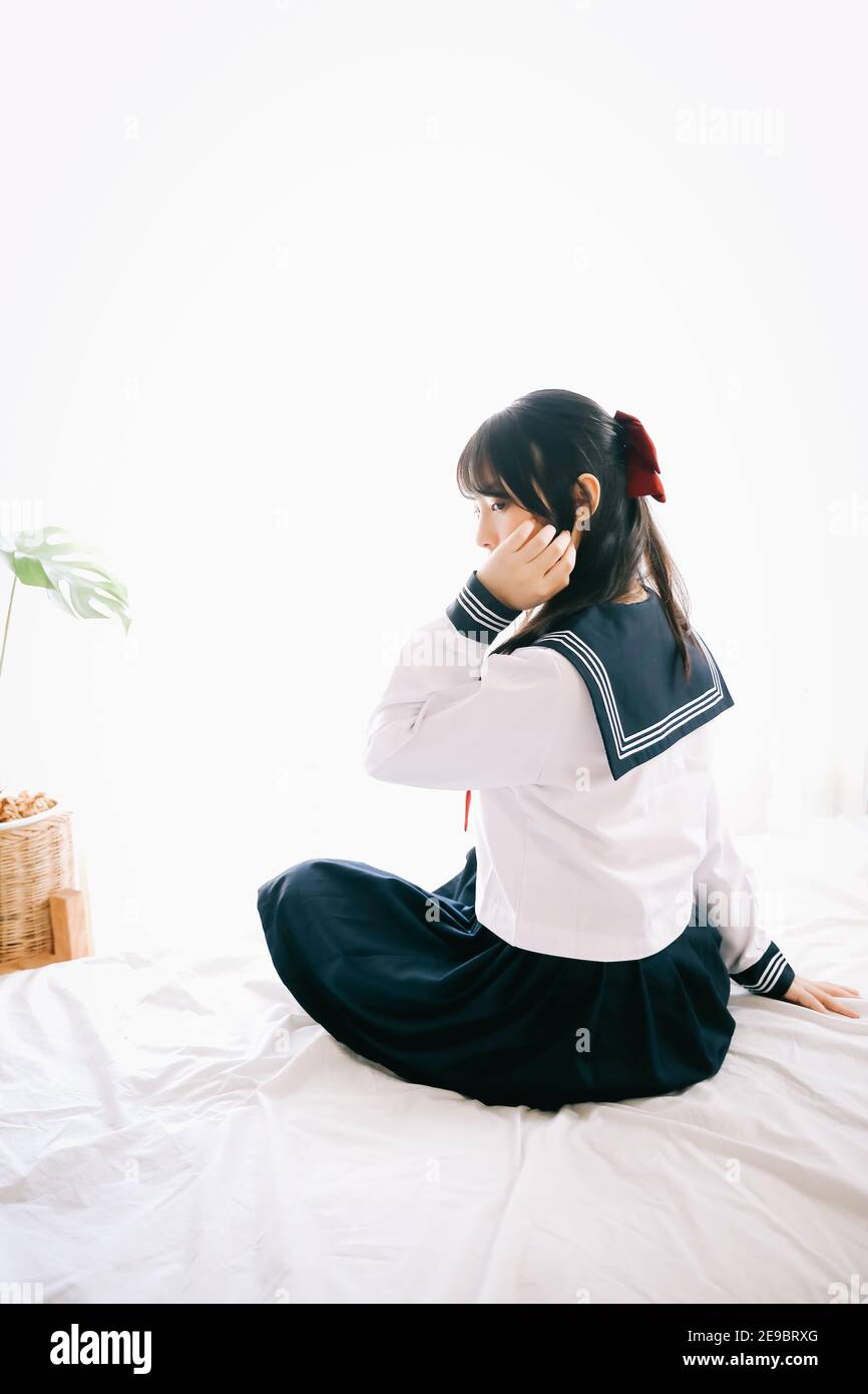 japanese school girl sitting on bedroom in white tone Stock Photo - Alamy