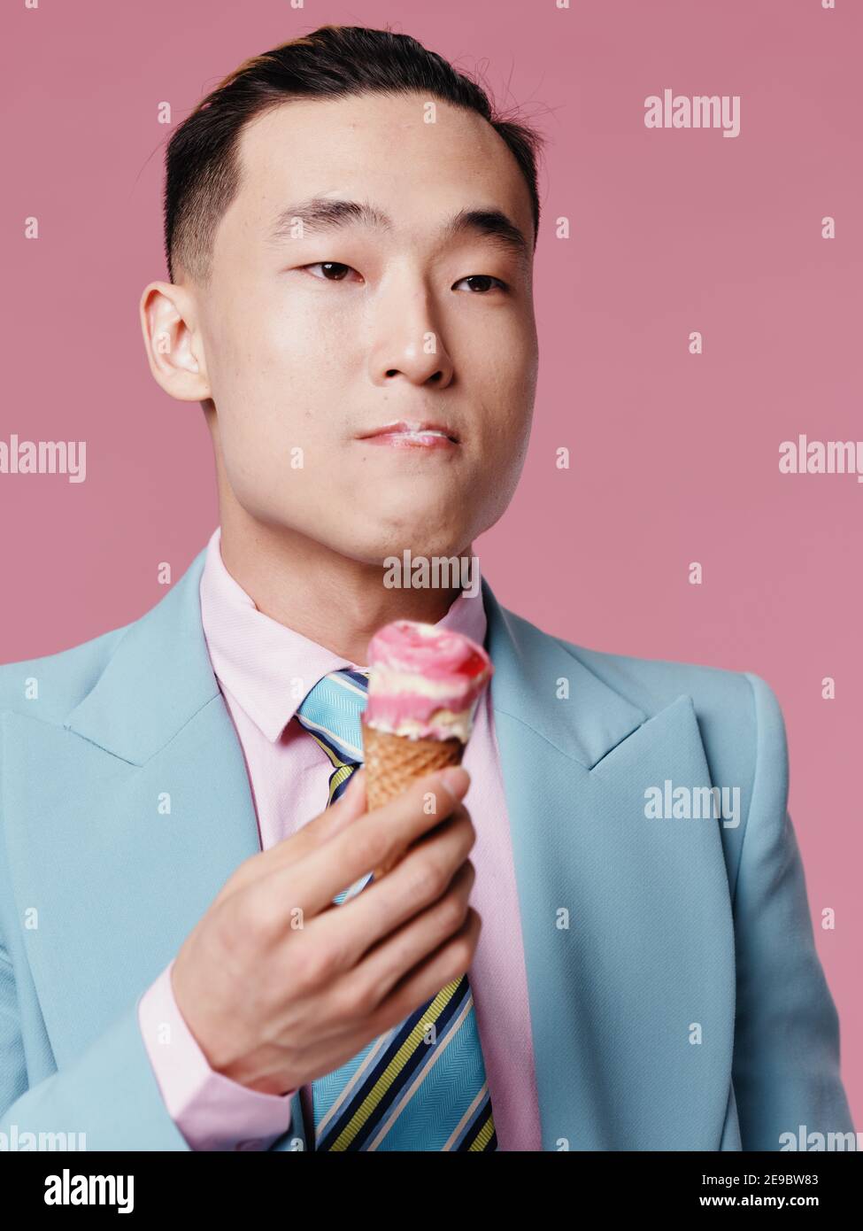 Man in blue classic suit with ice cream portrait pink background model ...