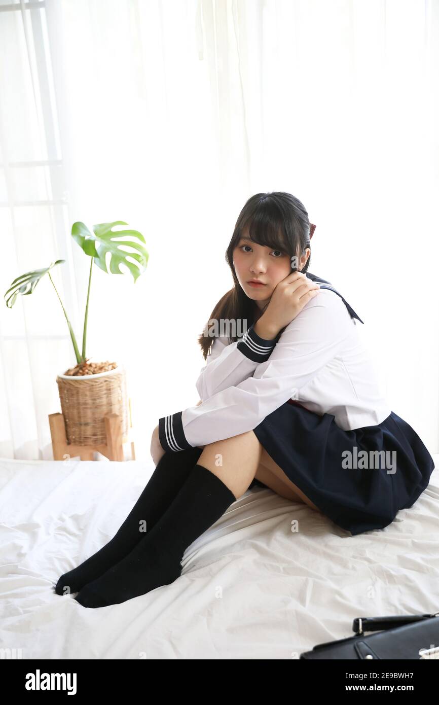 japanese school girl sitting on bedroom in white tone Stock Photo - Alamy