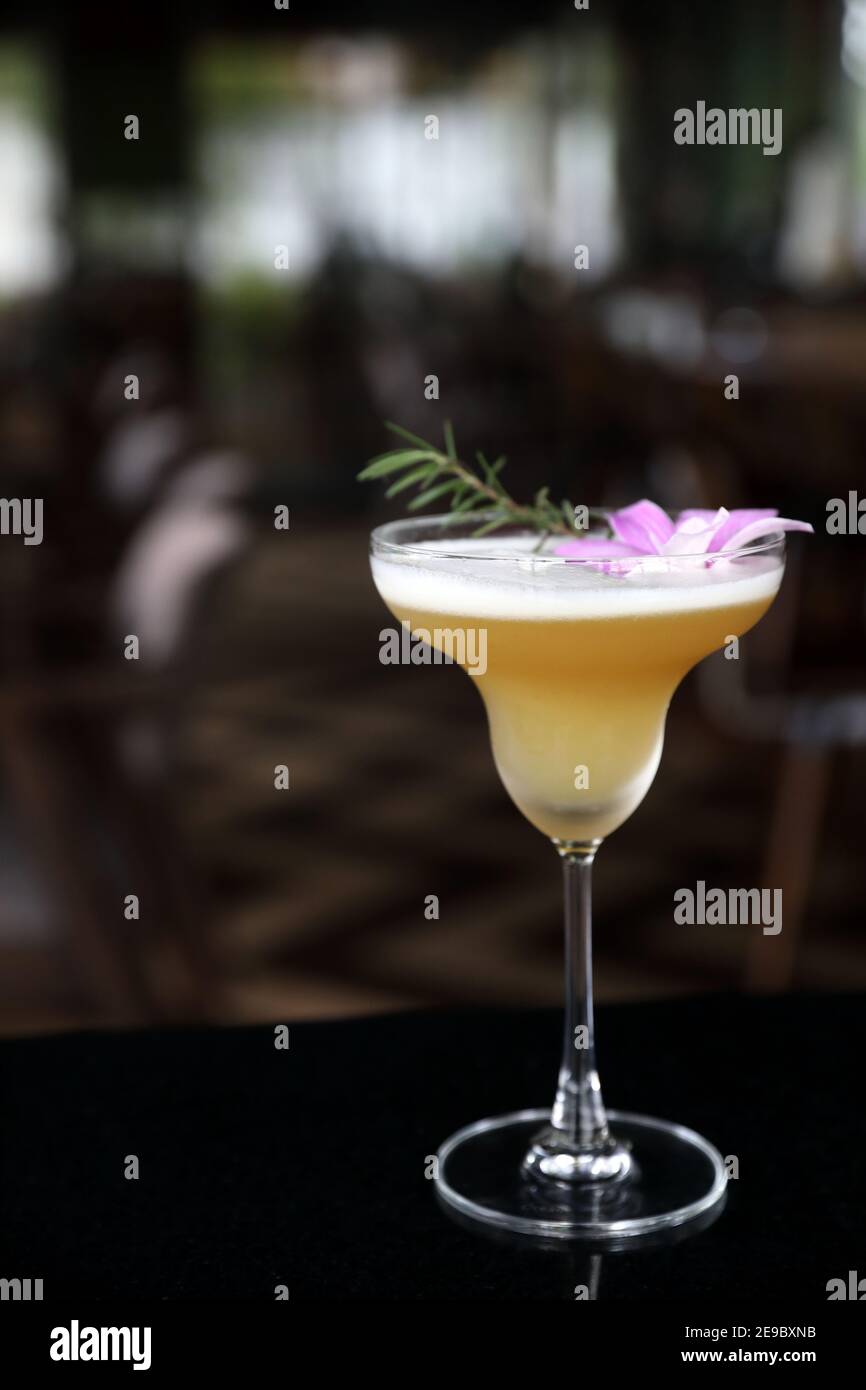 Yellow Cocktail glass with ice at a bar counter Stock Photo - Alamy