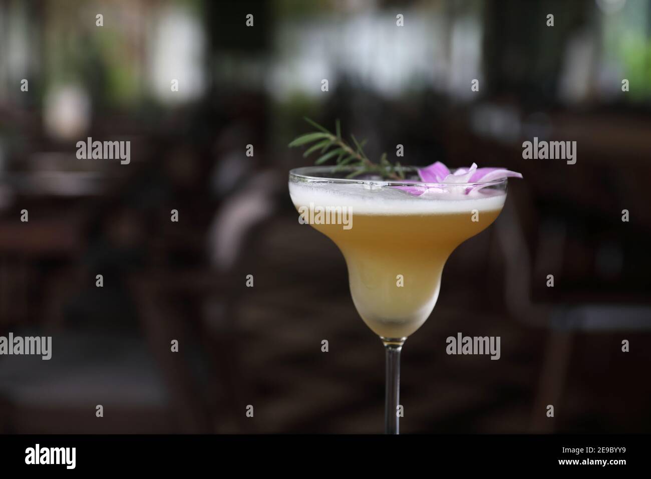 Yellow Cocktail glass with ice at a bar counter Stock Photo - Alamy