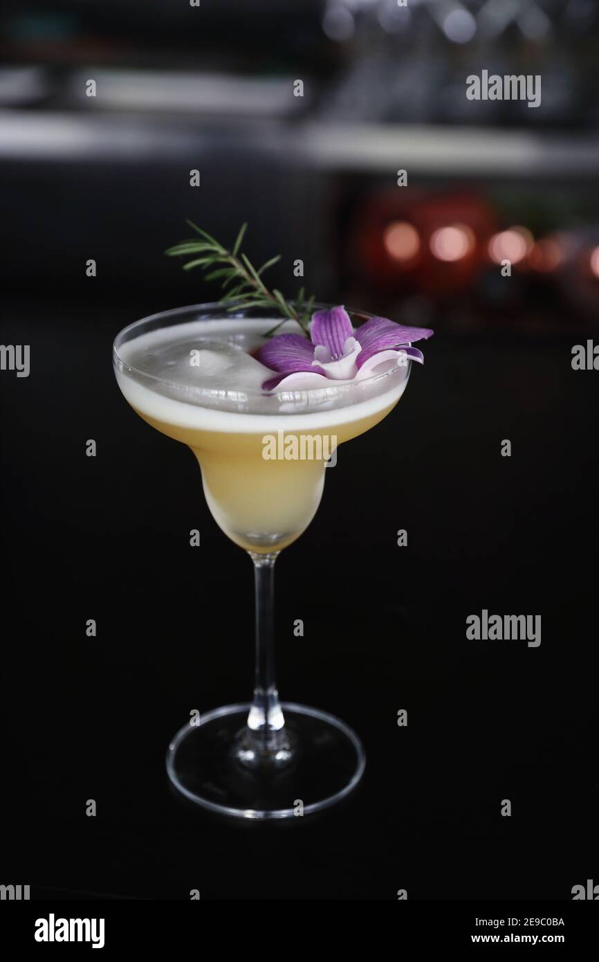 Yellow Cocktail glass with ice at a bar counter Stock Photo - Alamy