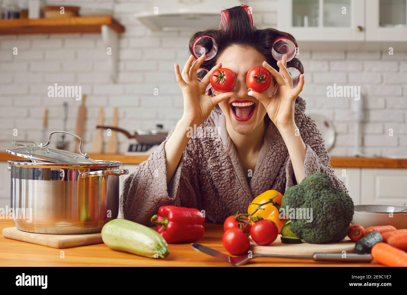 Cheerful young woman having fun while cooking healthy vegetable soup in ...