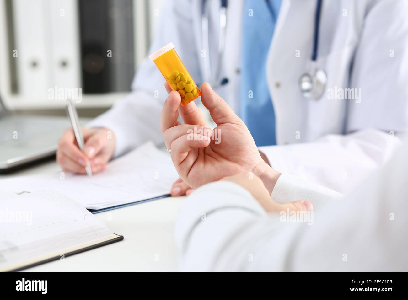 Female medicine doctor write prescription at worktable Stock Photo - Alamy