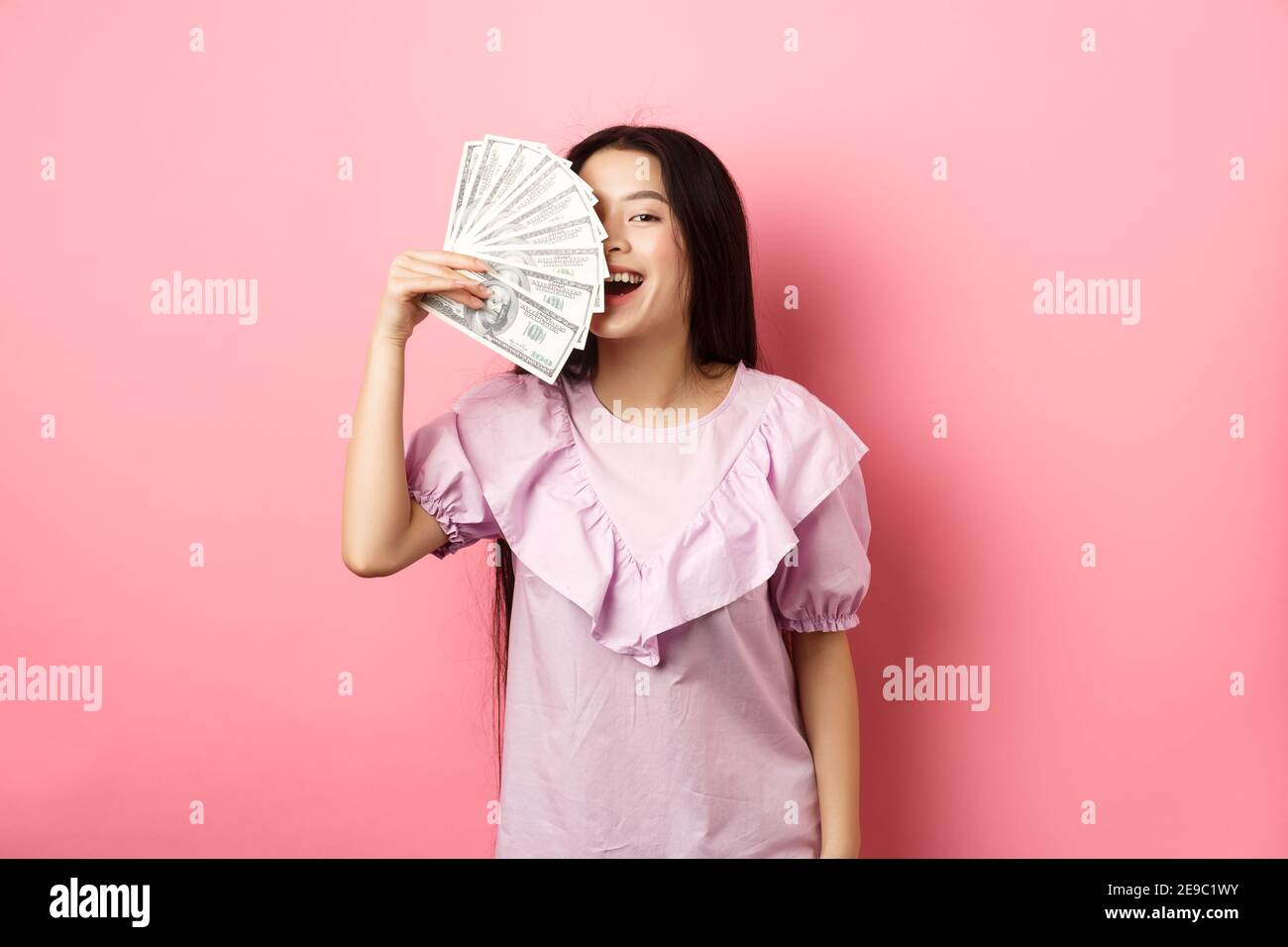 Happy rich asian woman showing money and smiling, shopping with cash ...