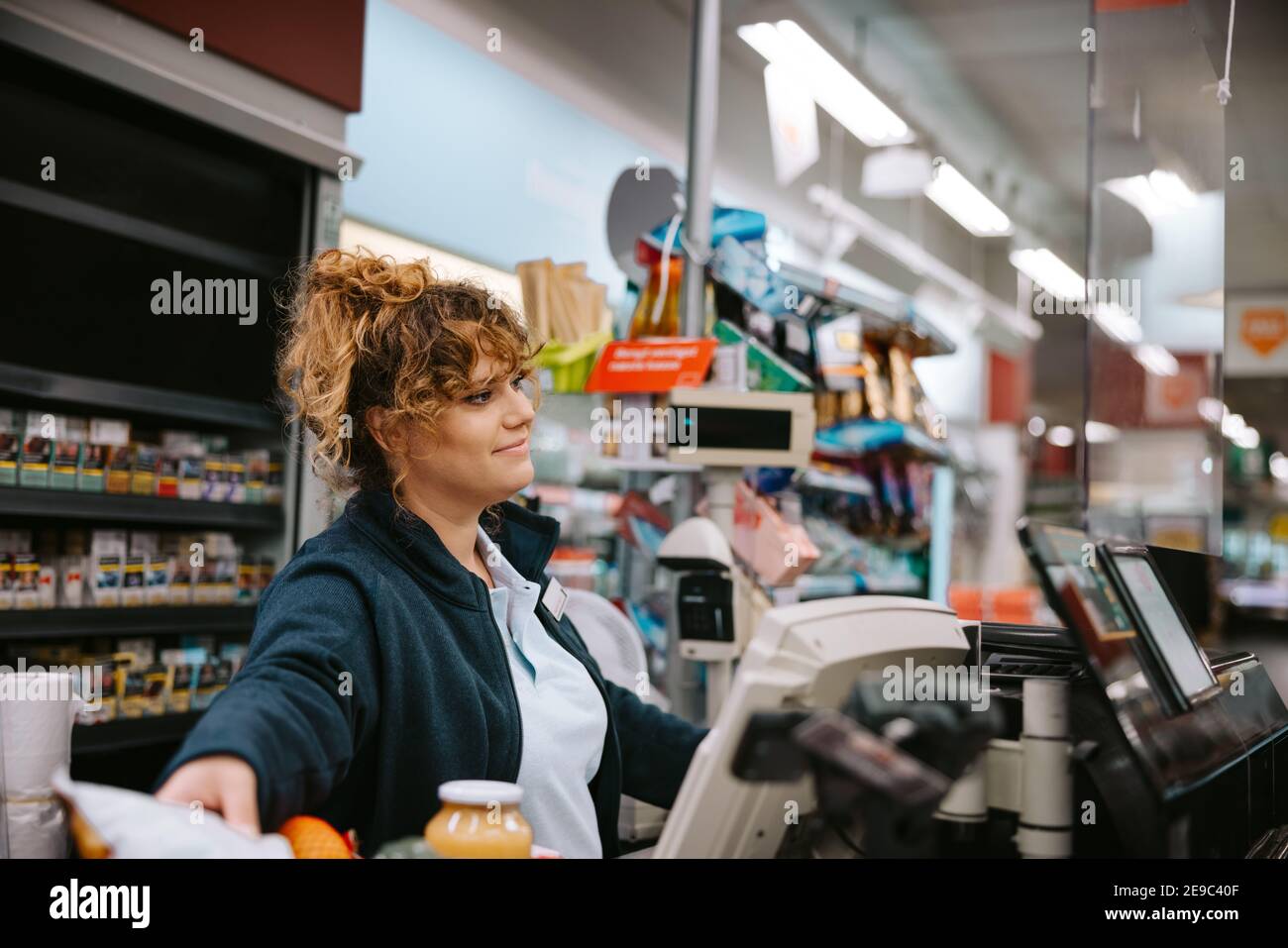 Woman working as a cashier in grocery store. Female cashier attending ...