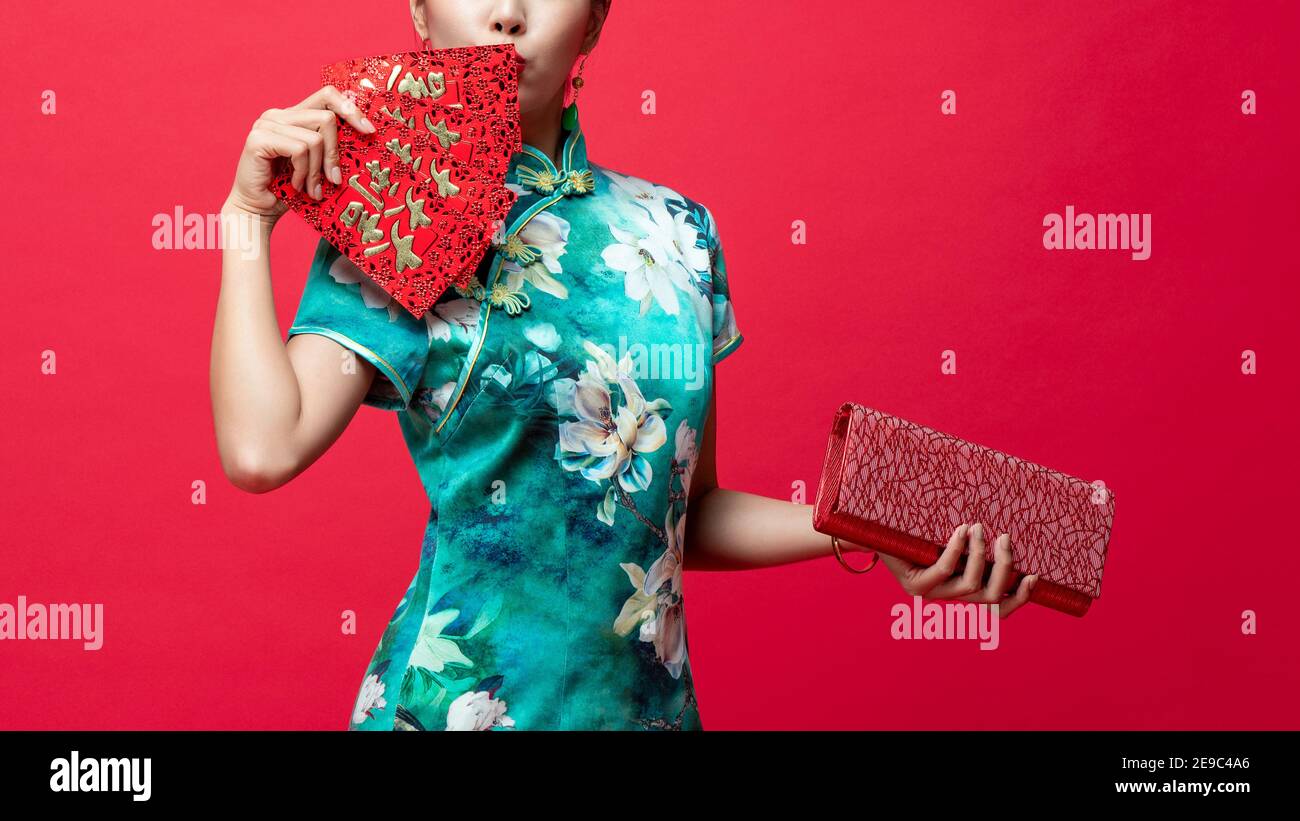 Woman wearing oriental qipao dress holding Ang Pao or red envelopes and ...