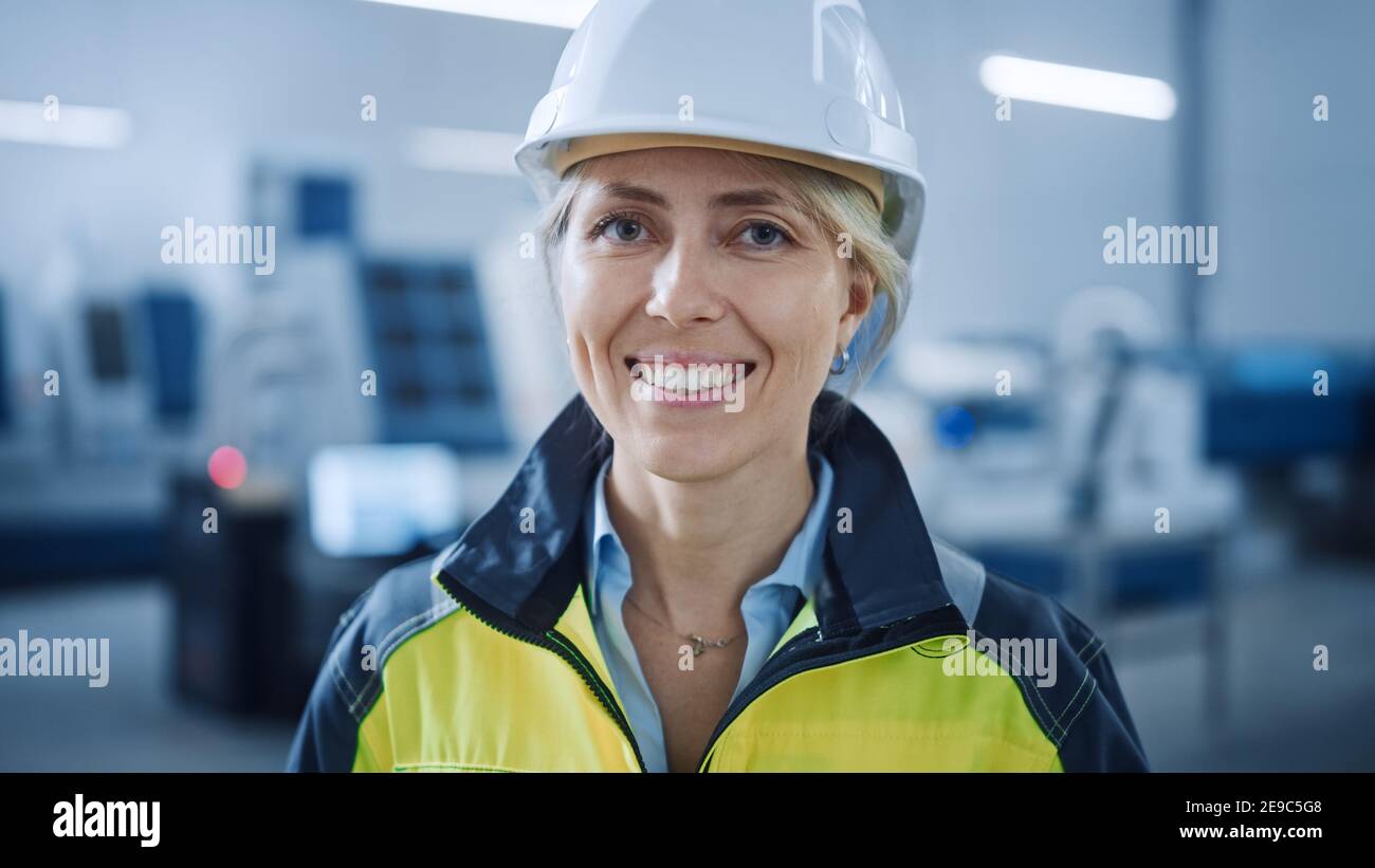 Portrait of Beautiful Smiling on Camera Female Engineer in Safety Vest and Hardhat. Professional ...