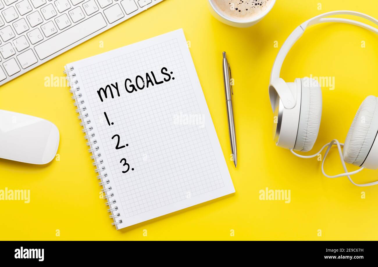 Office desk with supplies, headphones and notepad with my goals list ...