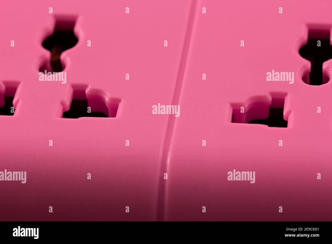 Closeup picture of a pink outlet isolated on black. Electric Power Line ...