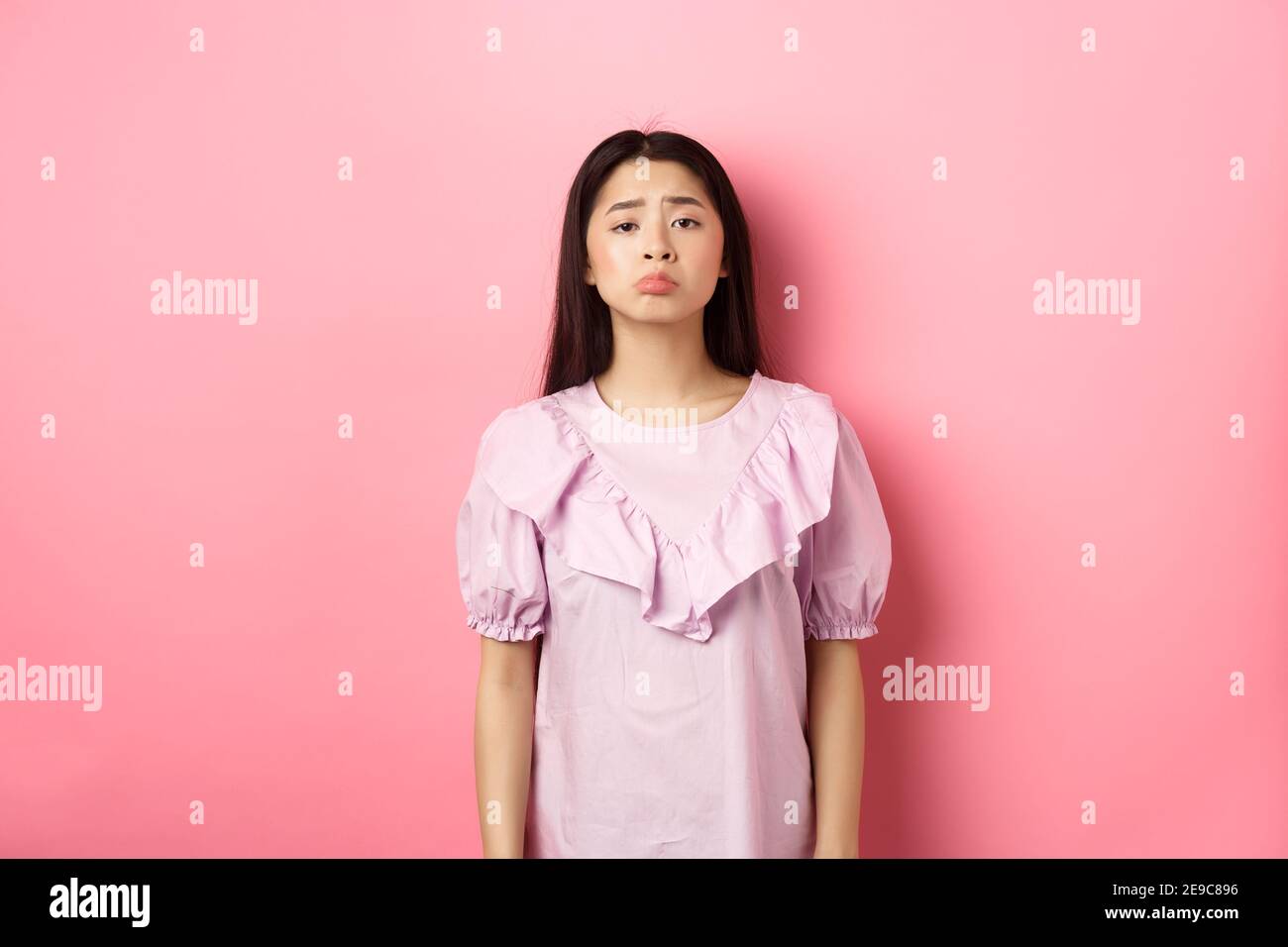 Sad whining asian girl pouting and frowning, looking upset about ...
