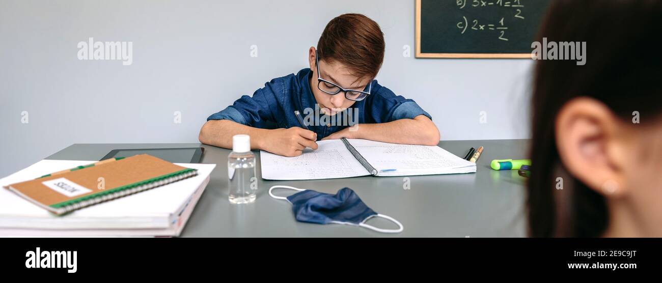 Boy writing in his notebook at school Stock Photo - Alamy