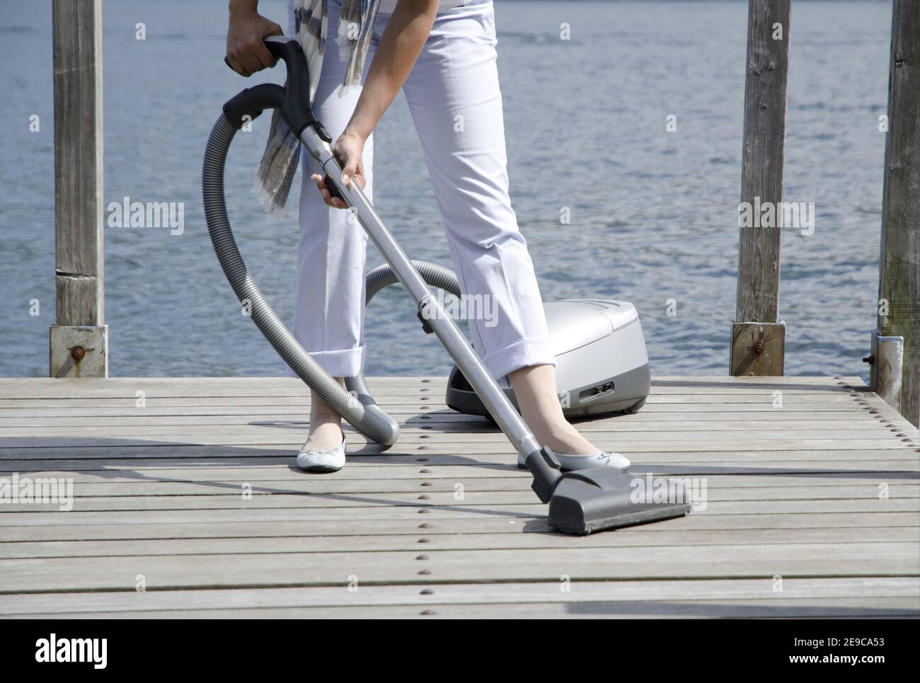 Woman Using Vacuum Cleaner the Pier over the Alpine Lake with Cleaning ...