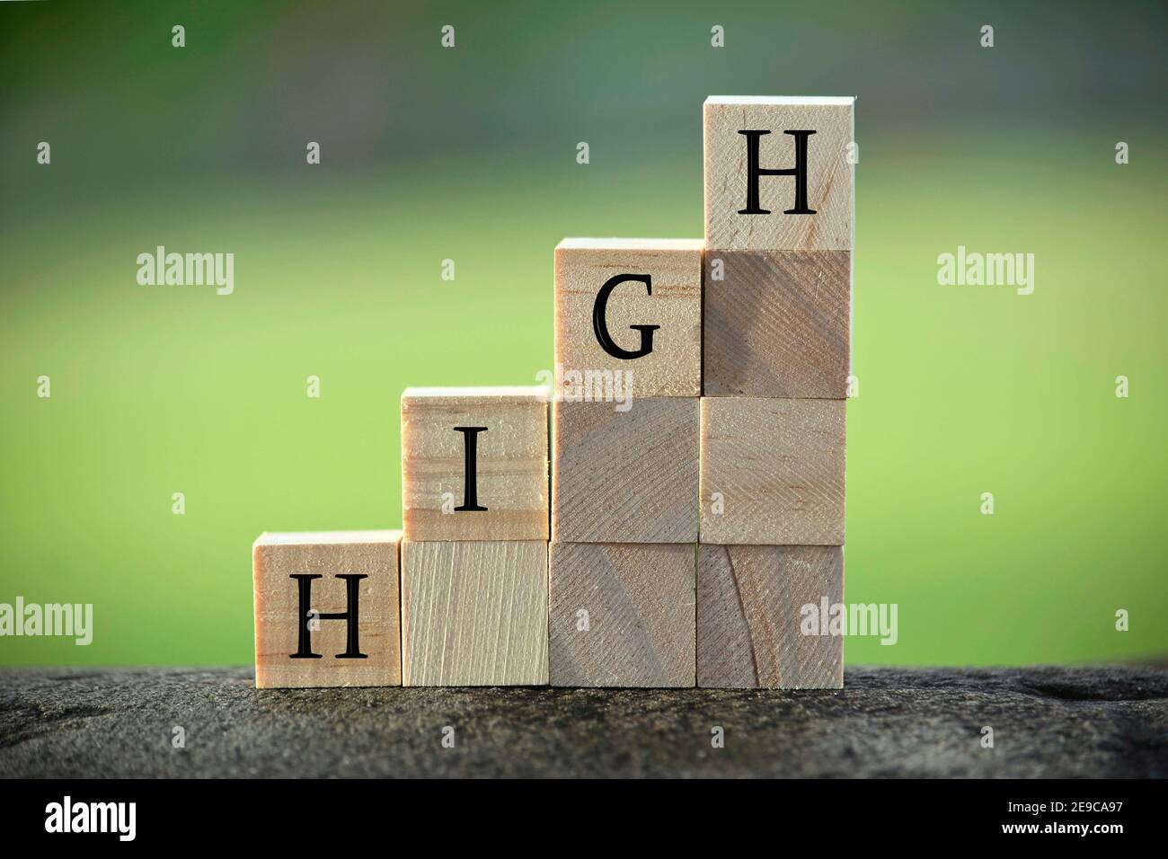 High text on wooden cube block on top of big stone with blurred ...