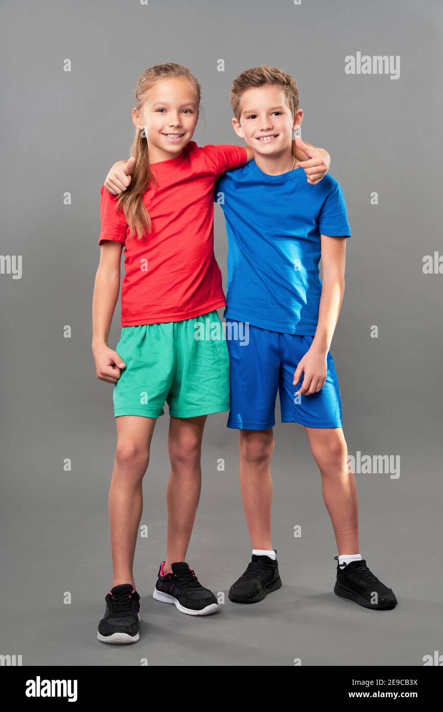 Cute female child wrapping arm around brother shoulder and smiling ... Cute female child wrapping arm around brother shoulder and smiling ...