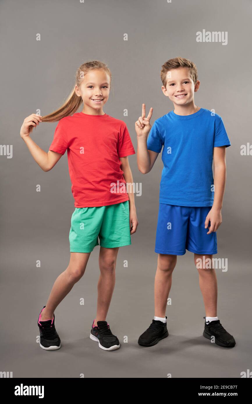 Adorable female child looking at camera and smiling while male kid ...