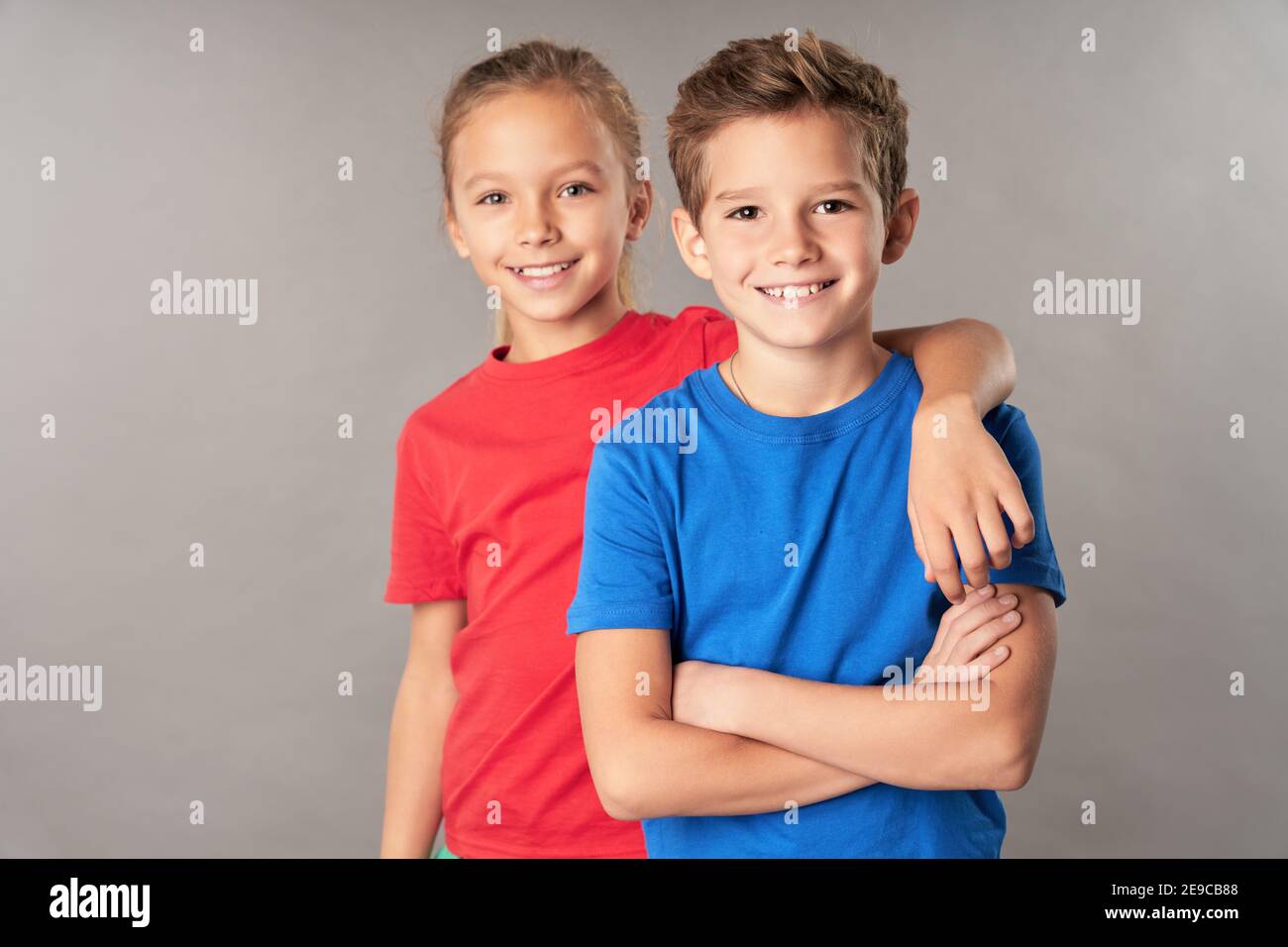 Adorable female child wrapping arm around brother shoulder and smiling ... Adorable female child wrapping arm around brother shoulder and smiling ...
