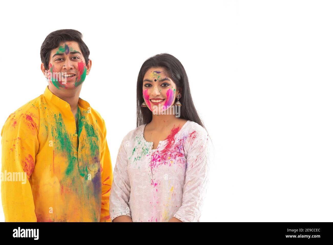A YOUNG MAN AND WOMAN POSING IN FRONT OF CAMERA WHILE CELEBRATING HOLI ...