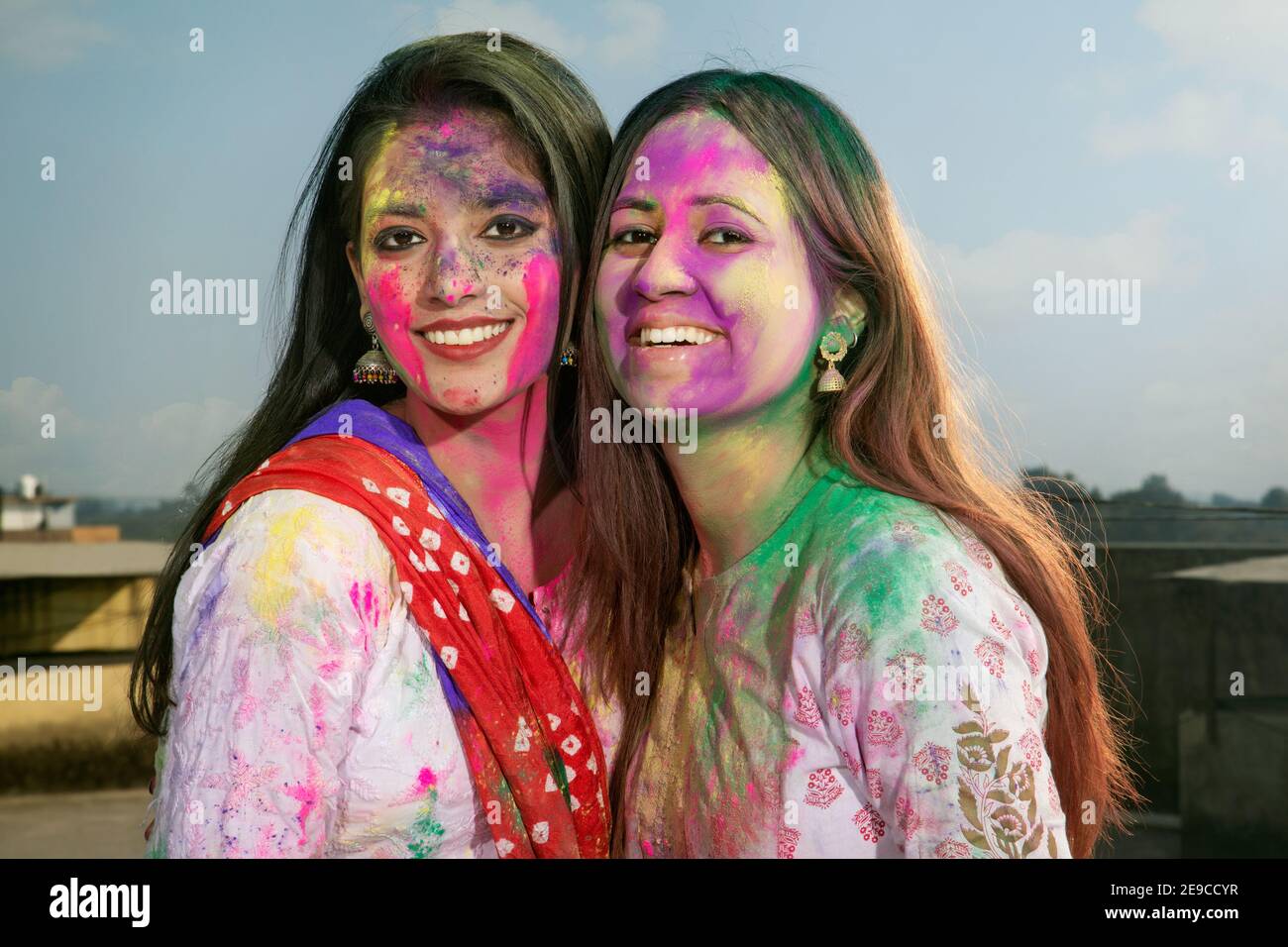 TWO YOUNG WOMEN POSING TOGETHER IN FRONT OF CAMERA DURING HOLI ...