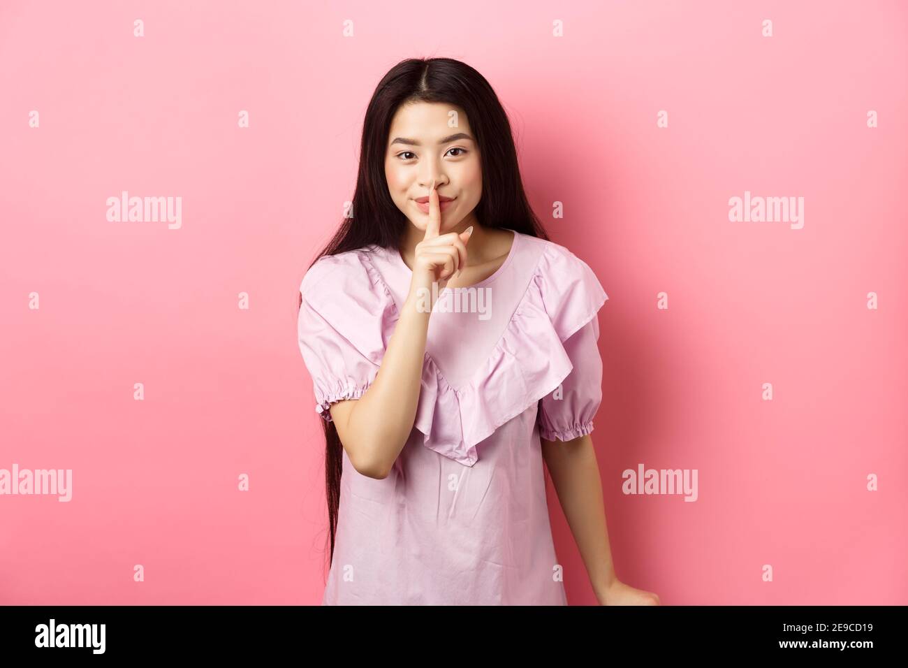 Cute asian girl hiding secret, hushing with finger pressed to lips and ...